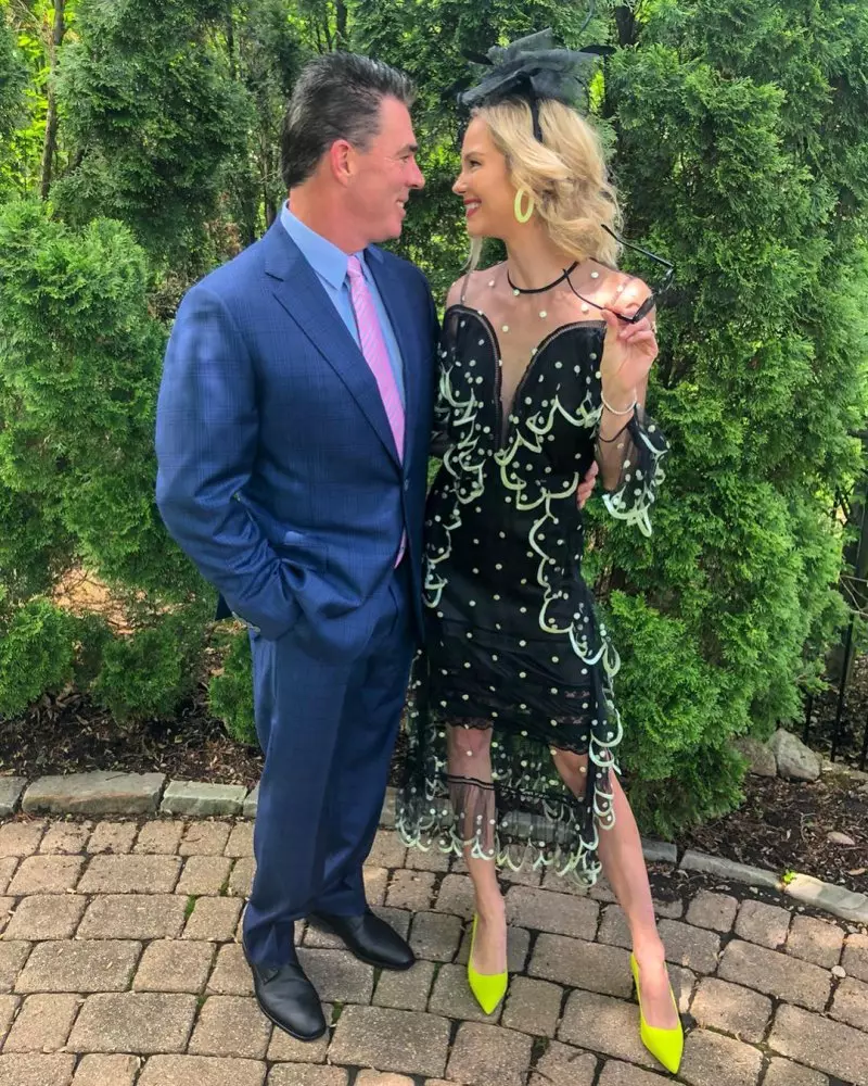 meghan king edmonds porte une robe noire avec des détails verts et des détails transparents avec des talons vert citron et un fascinateur assorti tandis que jim edmonds porte une chemise bleu clair et une cravate rose sous un costume bleu avec des chaussures noires