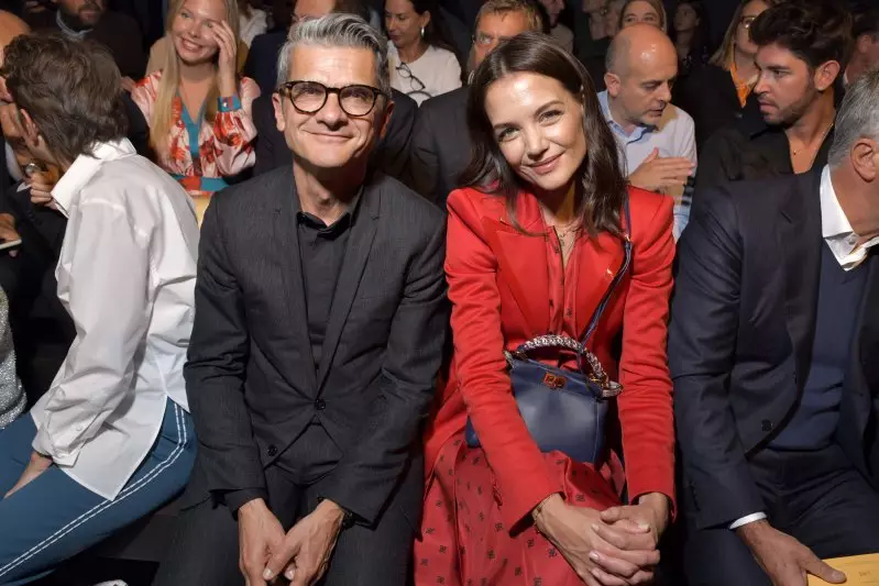 Katie Holmes vestindo un vestido vermello durante un desfile de moda