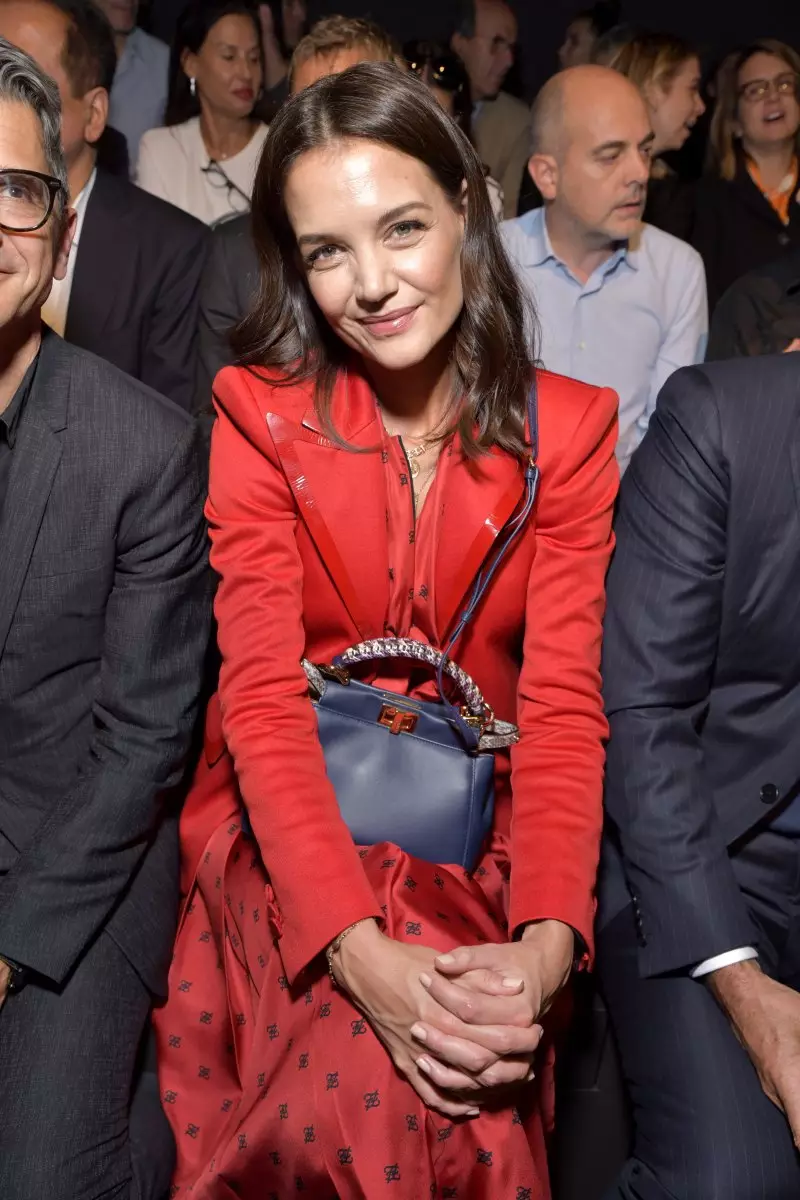 Katie Holmes vestindo un vestido vermello durante un desfile de moda