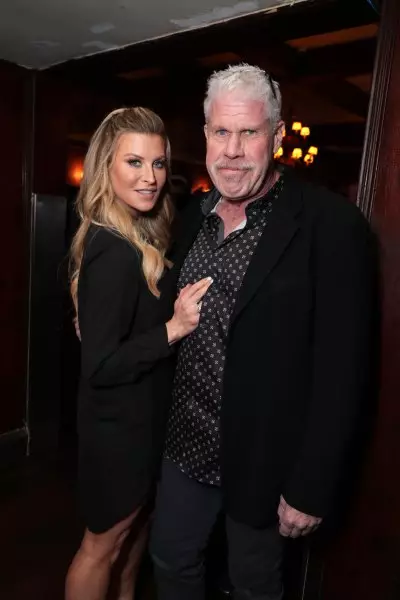 Ron Perlman iført en svart dress med Allison Dunbar i en svart kjole