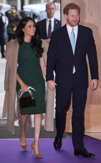 Meghan Markle usando um vestido verde com o príncipe Harry