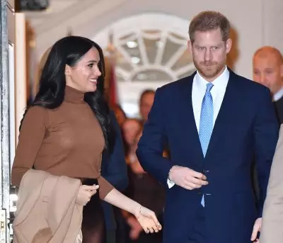 Meghan Markle vestindo unha camisa marrón co príncipe Harry