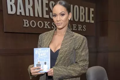 Evelyn Lozada leva unha chaqueta marrón cun top negro sostendo o seu libro: a cita perfecta.