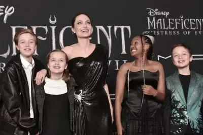 Angelina Jolie con un vestido negro con sus hijos