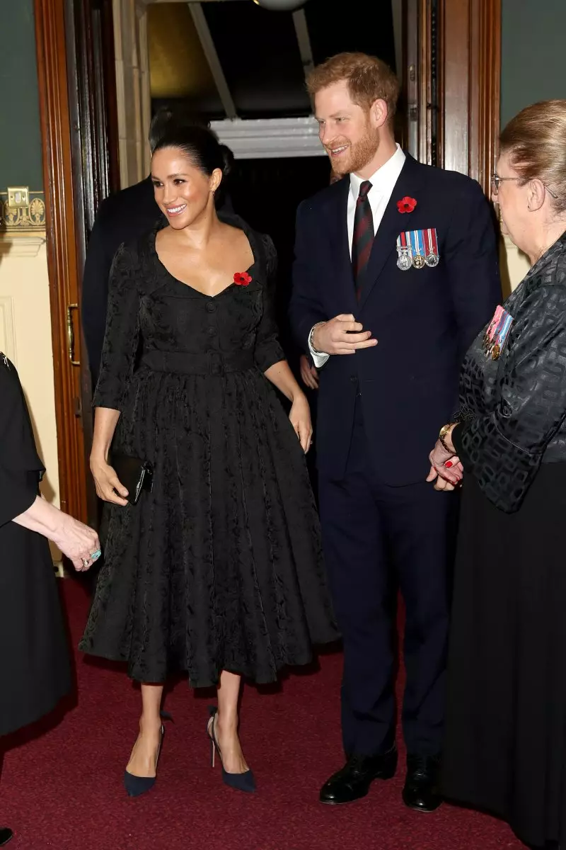 meghan markle usou um vestido preto com decote em V, enquanto o príncipe harry usava um terno azul marinho com camisa de botão e gravata listrada marinho e vermelha no festival da lembrança 2019