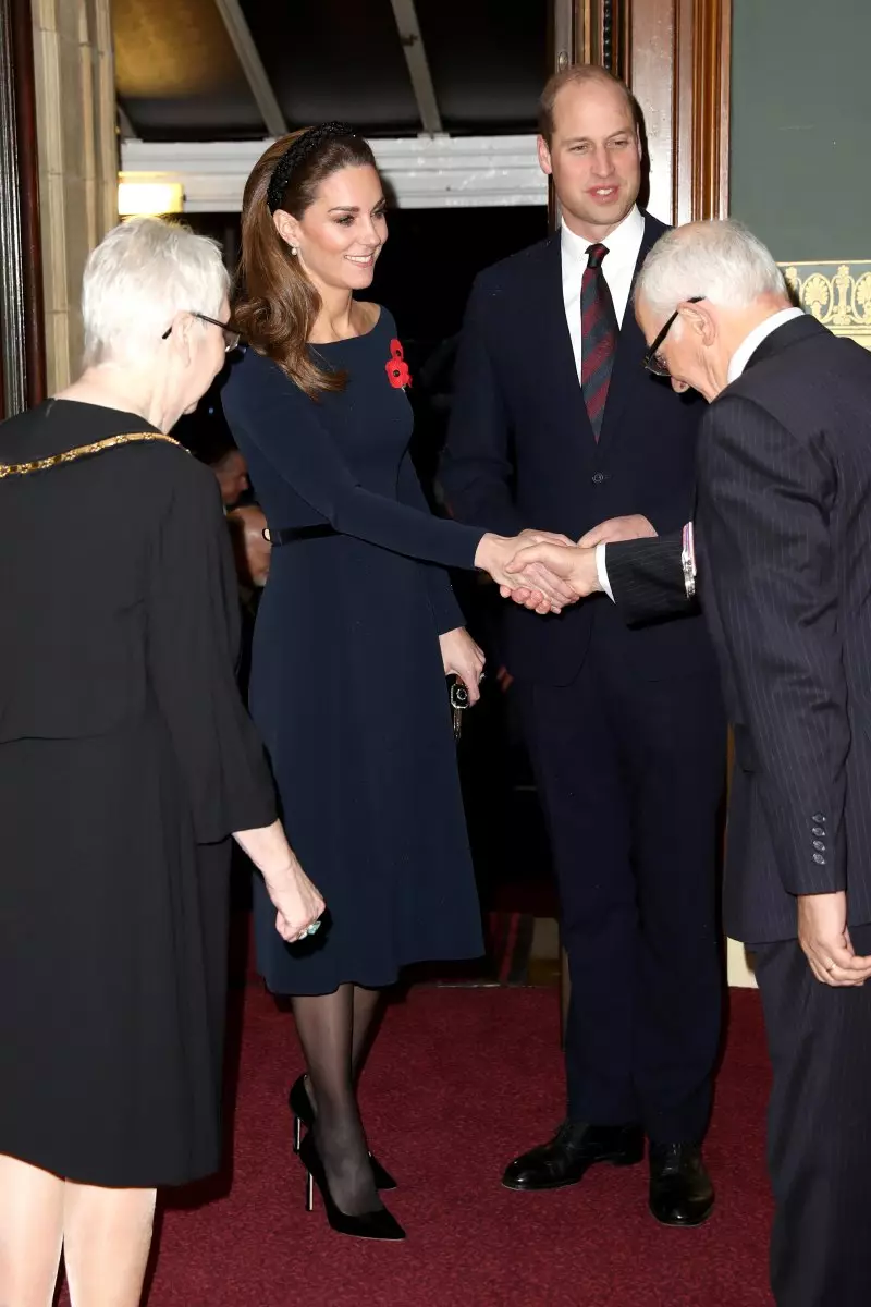 kate middleton usa um vestido azul marinho de manga longa na altura do joelho enquanto príncipe william usa um terno azul marinho com camisa branca de botão e gravata azul marinho e vermelha