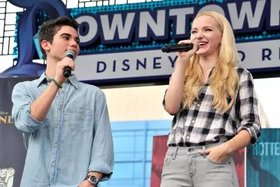 Dove Cameron mete yon chemiz plaid ak Cameron Boyce nan yon chemiz ble ak mikwofòn