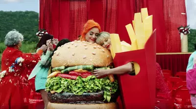 Taylor Swift indossa un costume da patatine fritte mentre abbraccia Katy Perry indossando un costume da hamburger durante il video musicale di You Need to Calm Down